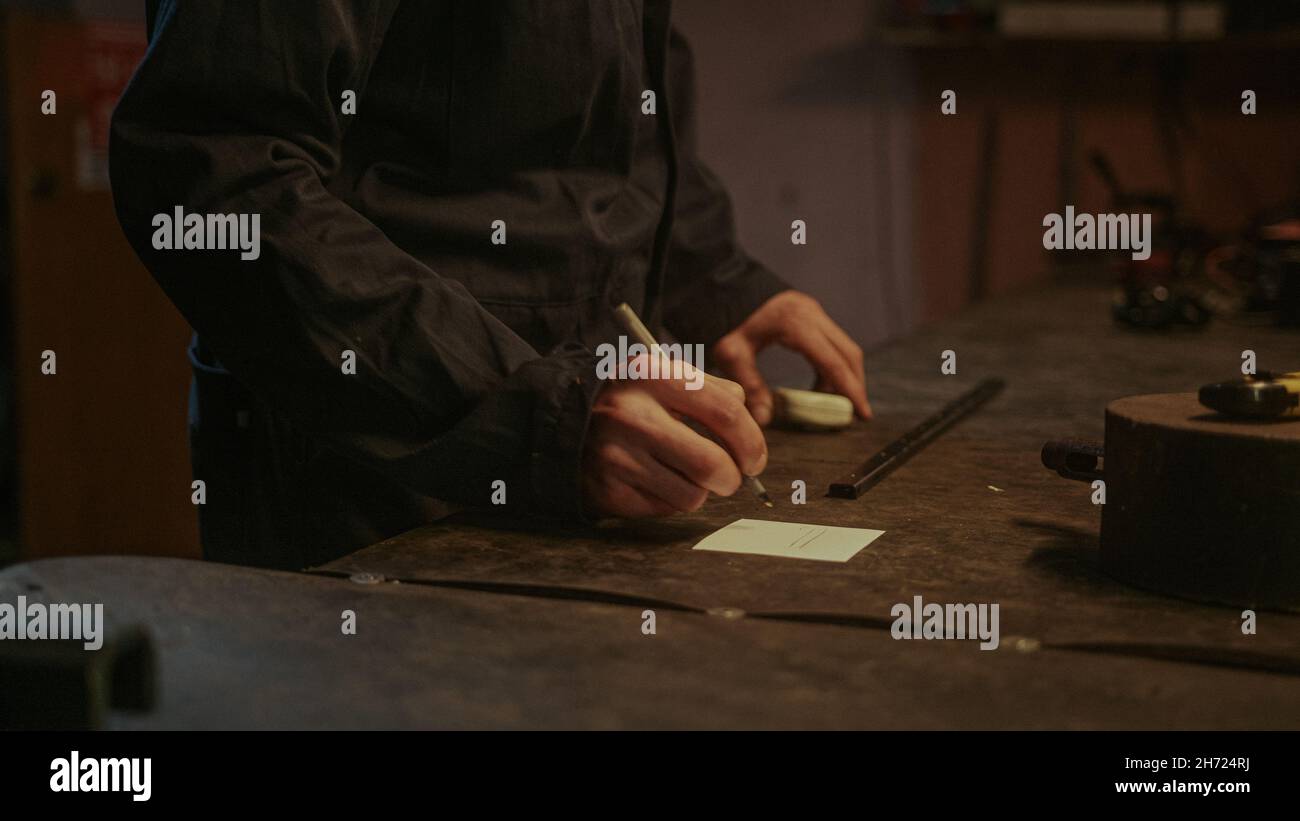 Worker man taking measurements from an iron stick and taking note on ...