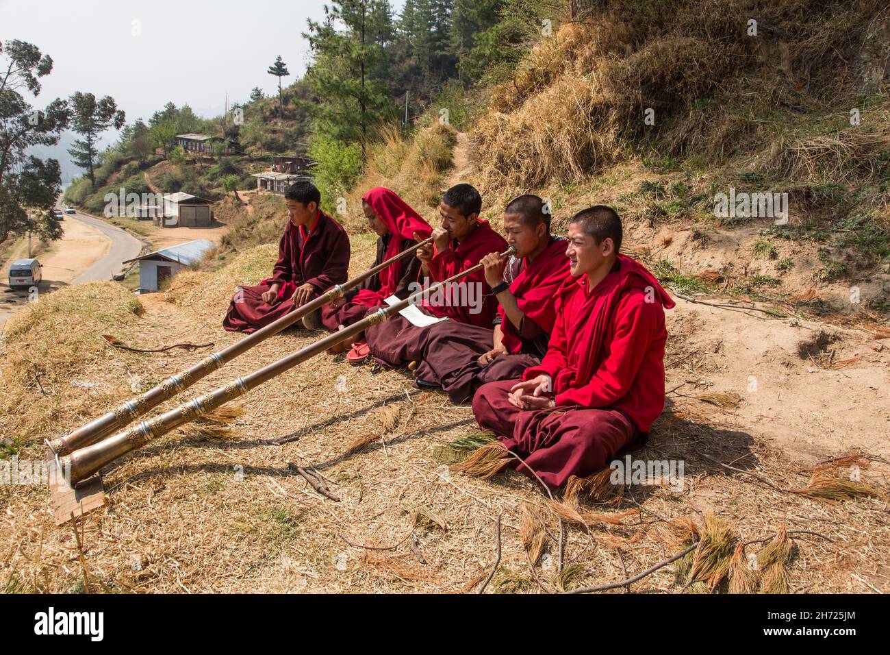 Young Buddhist monks practicing the Tibetan dungchen horn at the Dechen ...