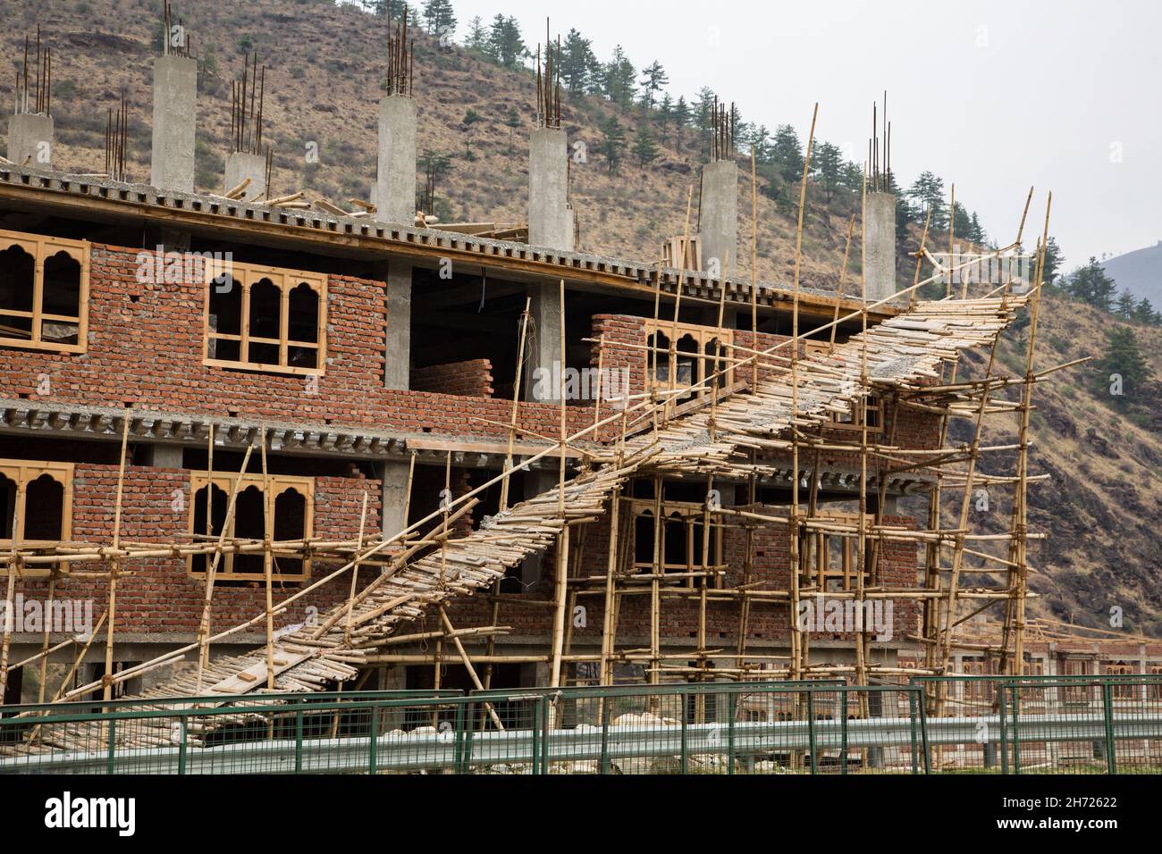 A bamboo ramp and bamboo scaffolding on a building under construction ...