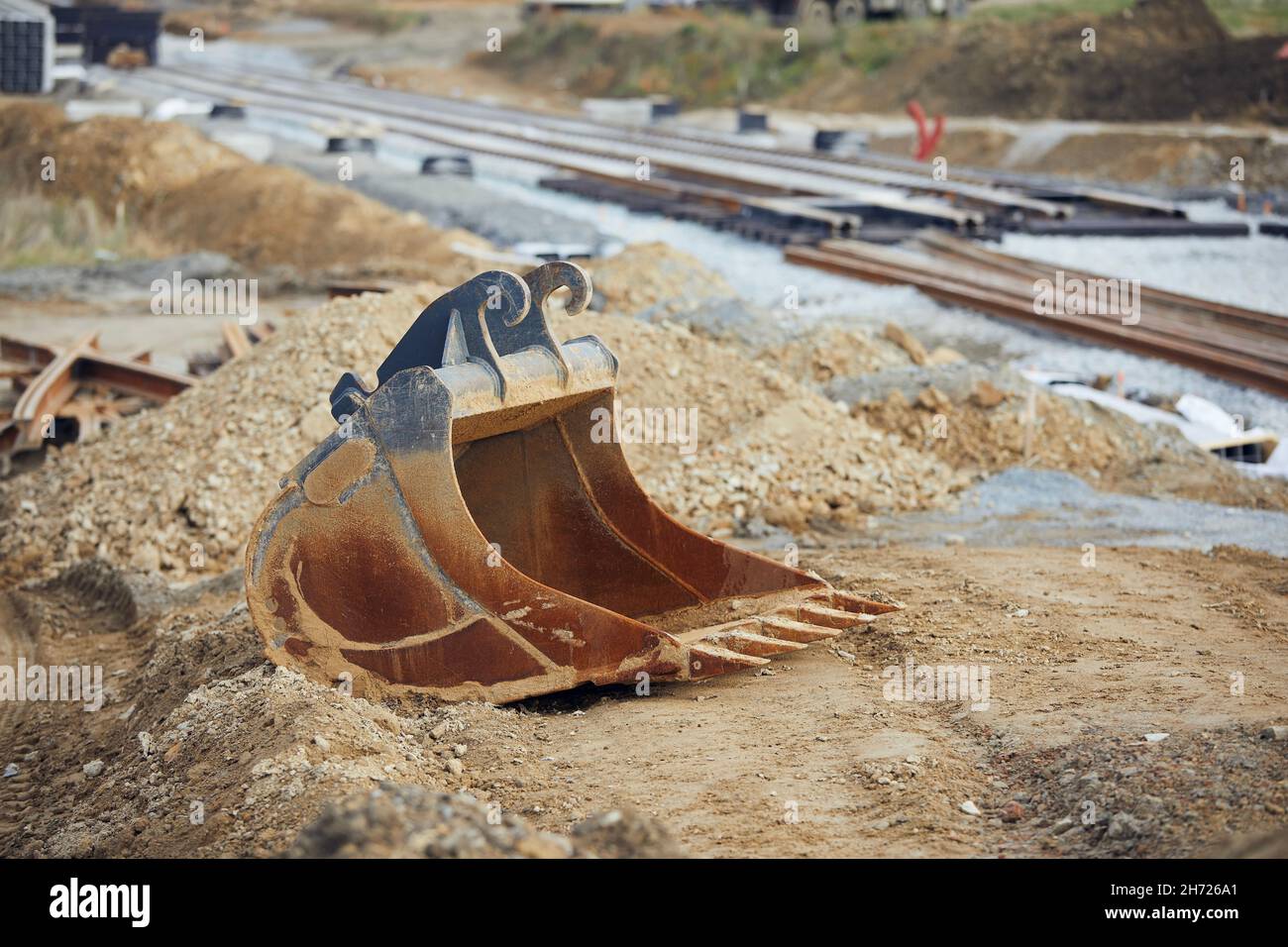 Building of railroad track. Excavator bucket on construction site of ...