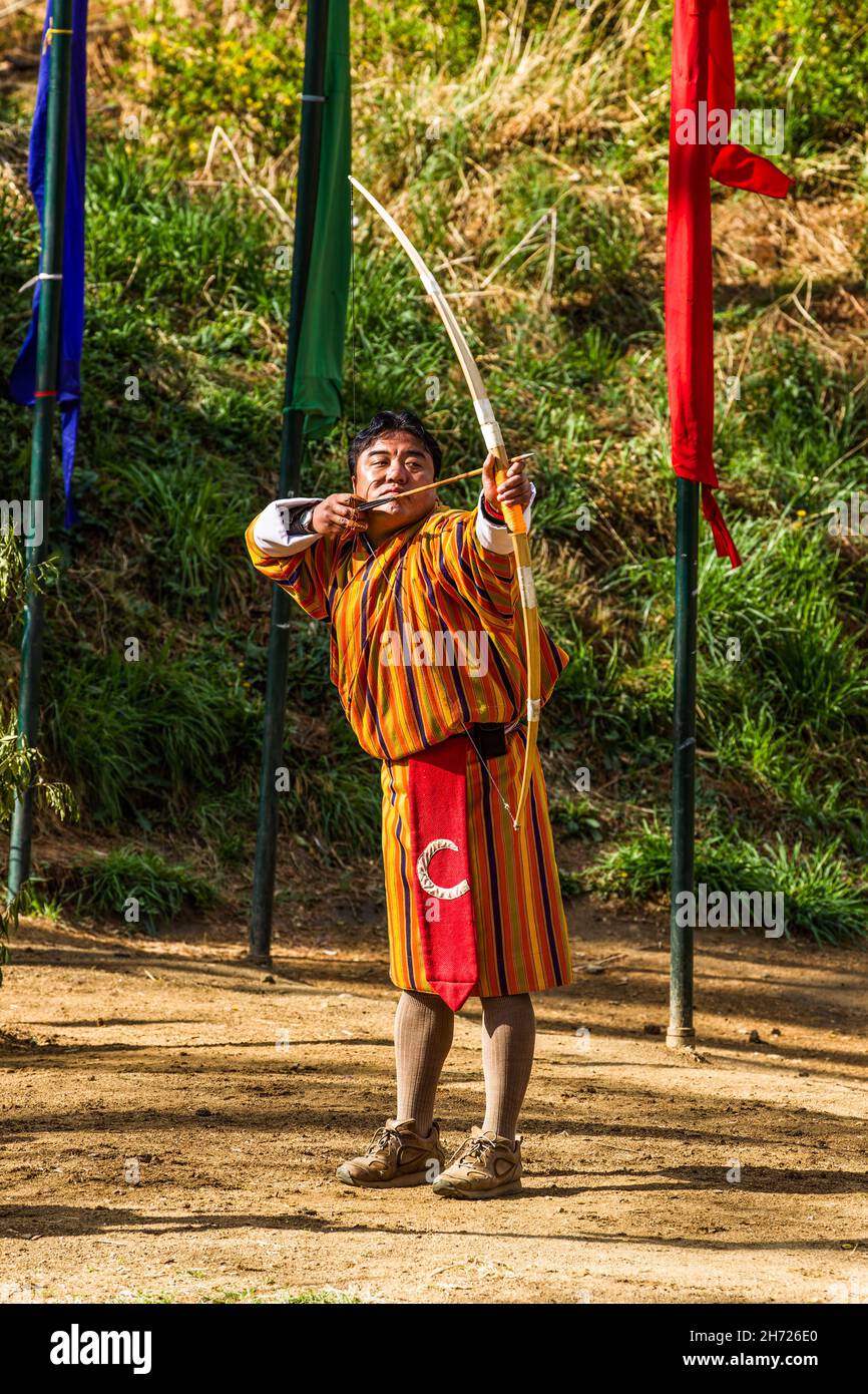 A Bhutanese archer competes with a recurved bow in an archery ...