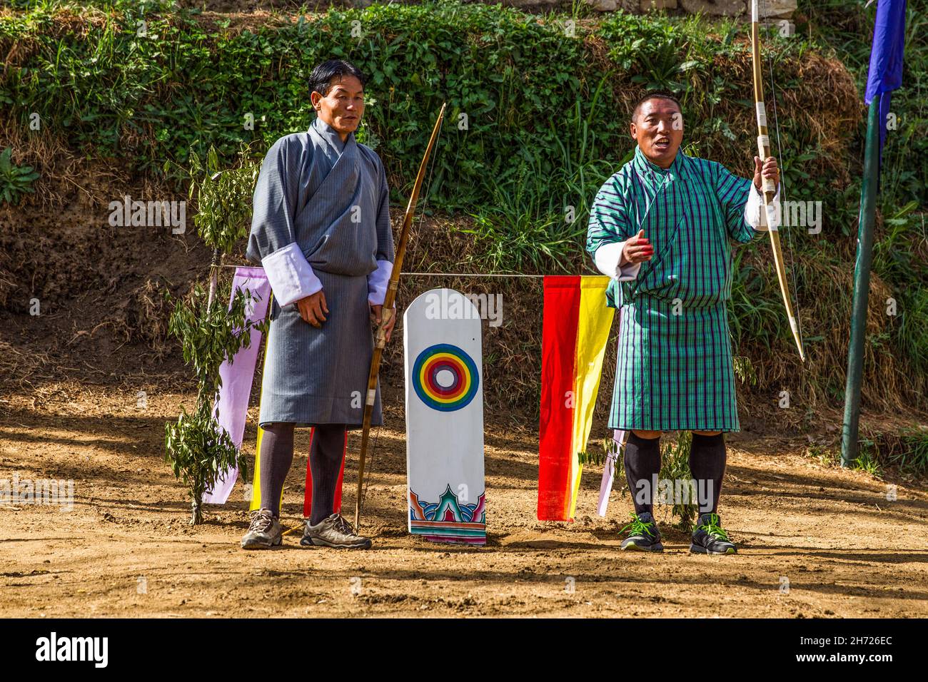 Bhutanese archers stand on either side of the target during an archery ...