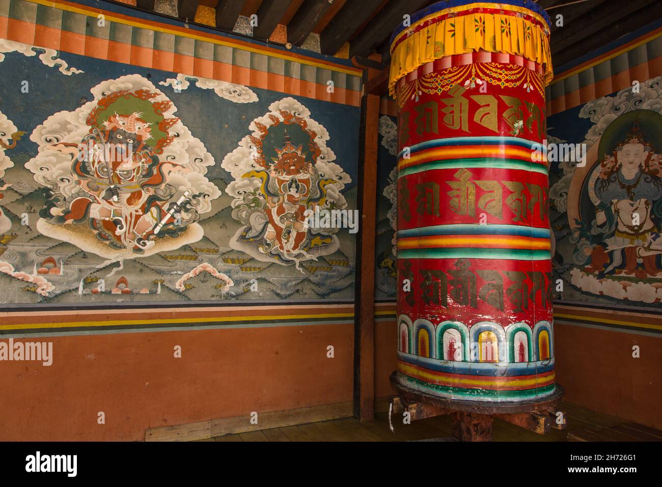 Buddhist religious art and a giant prayer wheel in the Dechen Phodrang ...