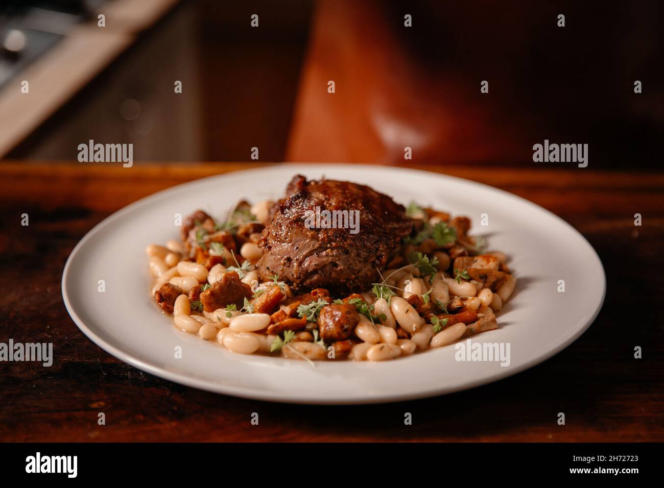 Professional chef cooking in the kitchen. A tasty dish with beef steak ...