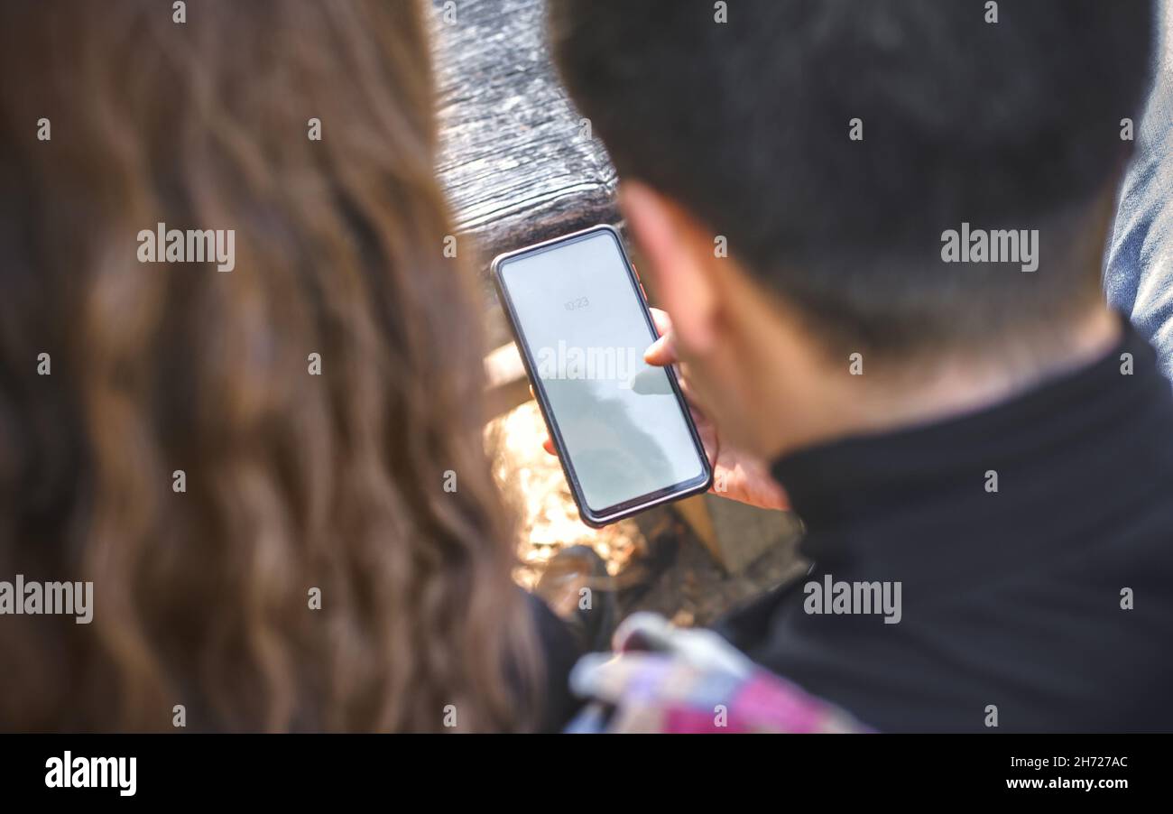 Woman and man looks at mobile phone from the top upper angle view ...
