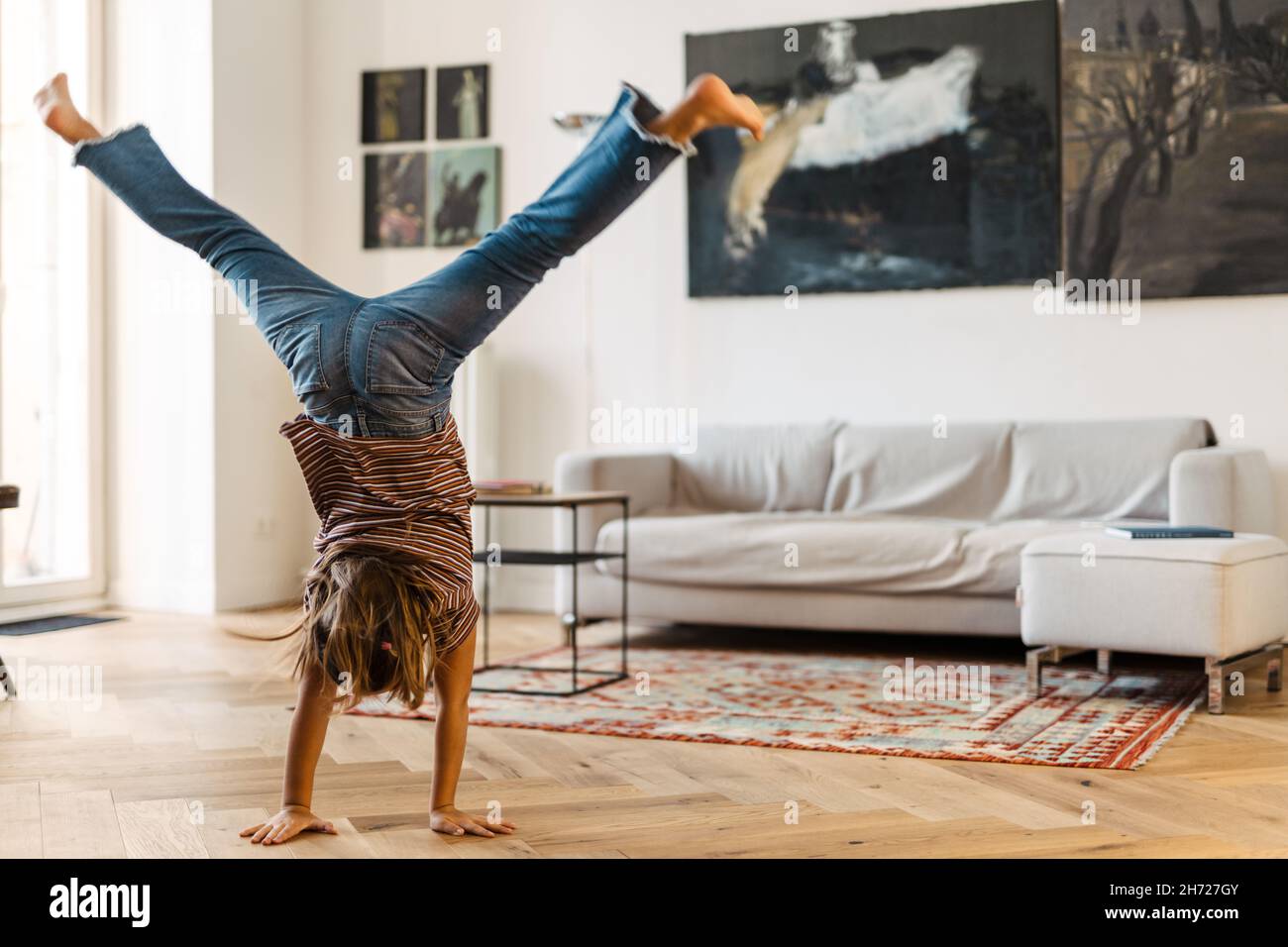 White preteen girl standing on her arms while making fun at home Stock ...