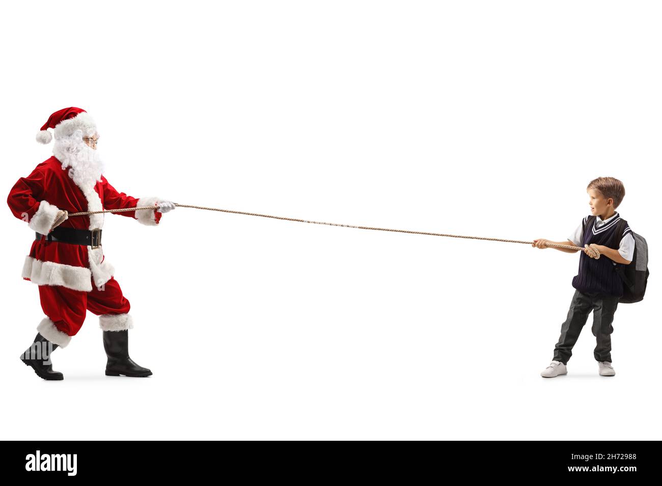 Full length profile shot of a schoolboy and santa claus pulling a rope ...