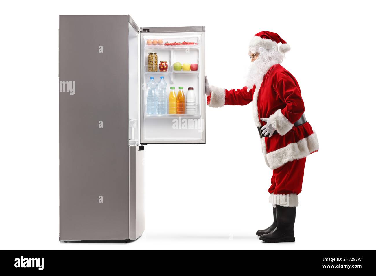 Full length profile shot of a Santa Claus standing in front of a fridge ...