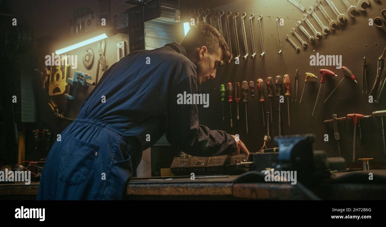 Blacksmith male person in awesome workshop background he sanding a ...