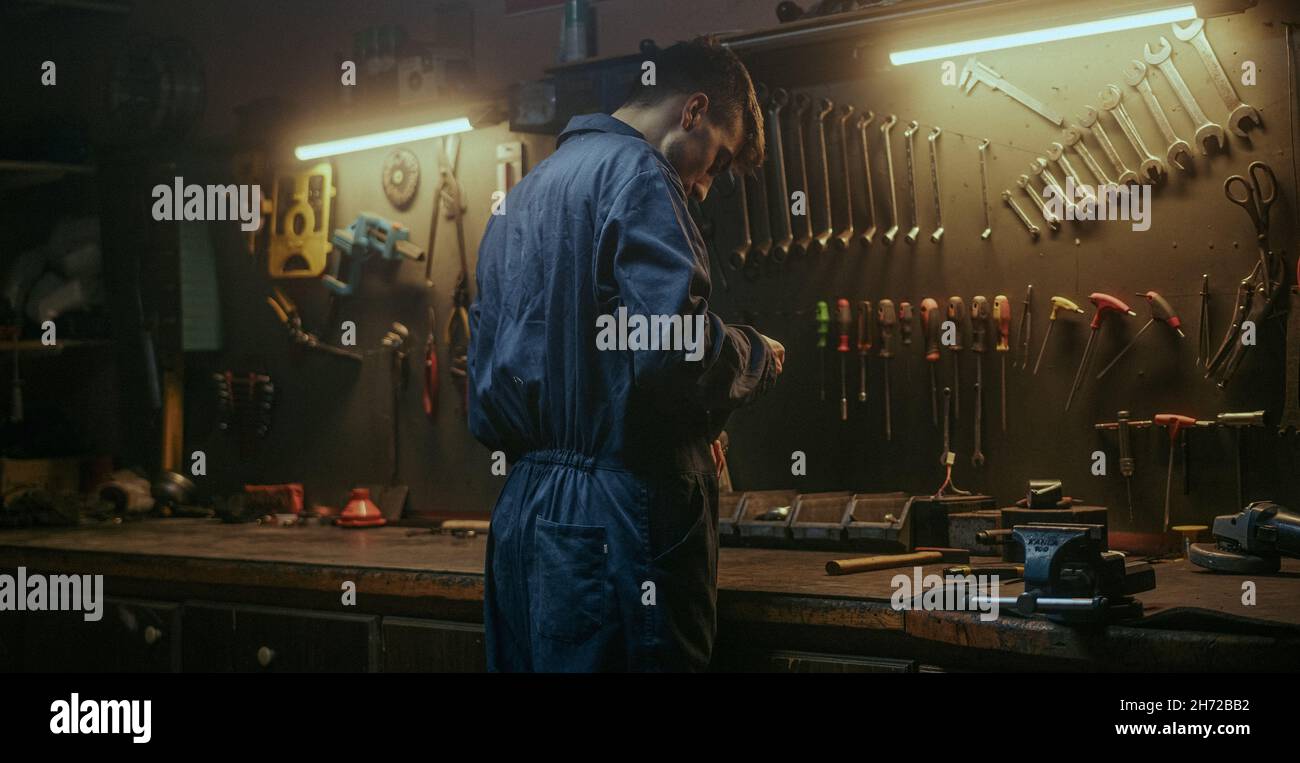 Young blacksmith man working standing at the workbench at his own ...