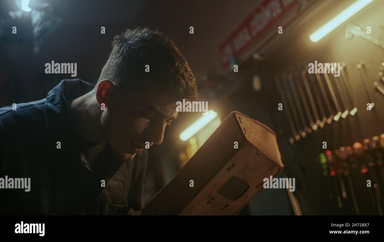 Young blacksmith man with welding shield using welding machine for ...