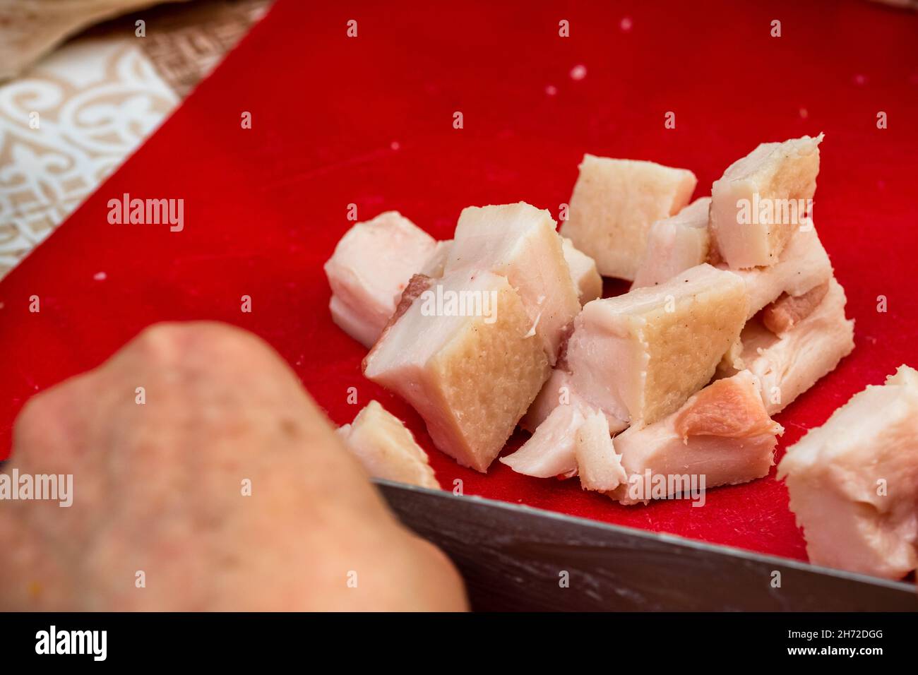 Butcher cutting little pieces of fat pork meat Stock Photo - Alamy