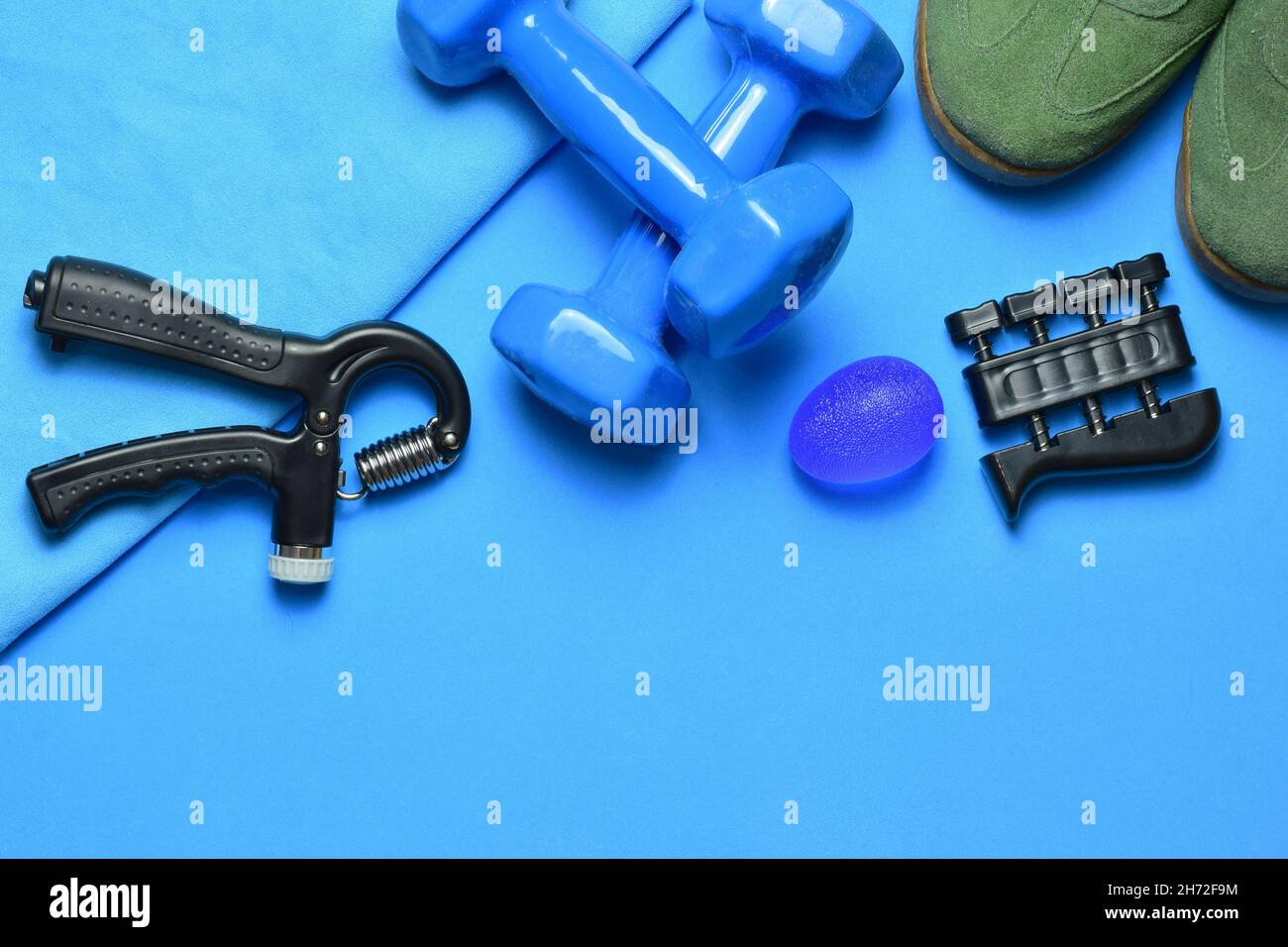 Top view of fitness tools. The dumbbells, hand and finger grips, boots ...
