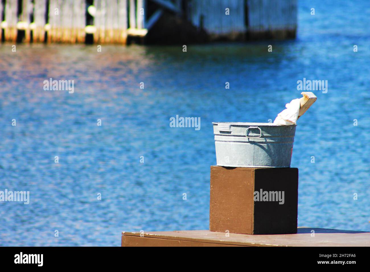 A steel bucket atop a post at the end of a pier Stock Photo - Alamy