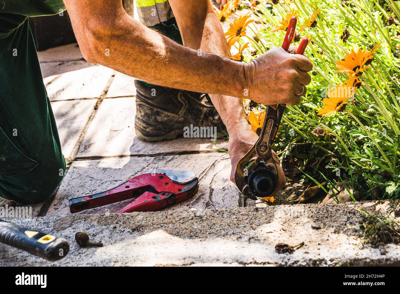 Worker in a special uniform fixing the tubes in the yard Stock Photo ...