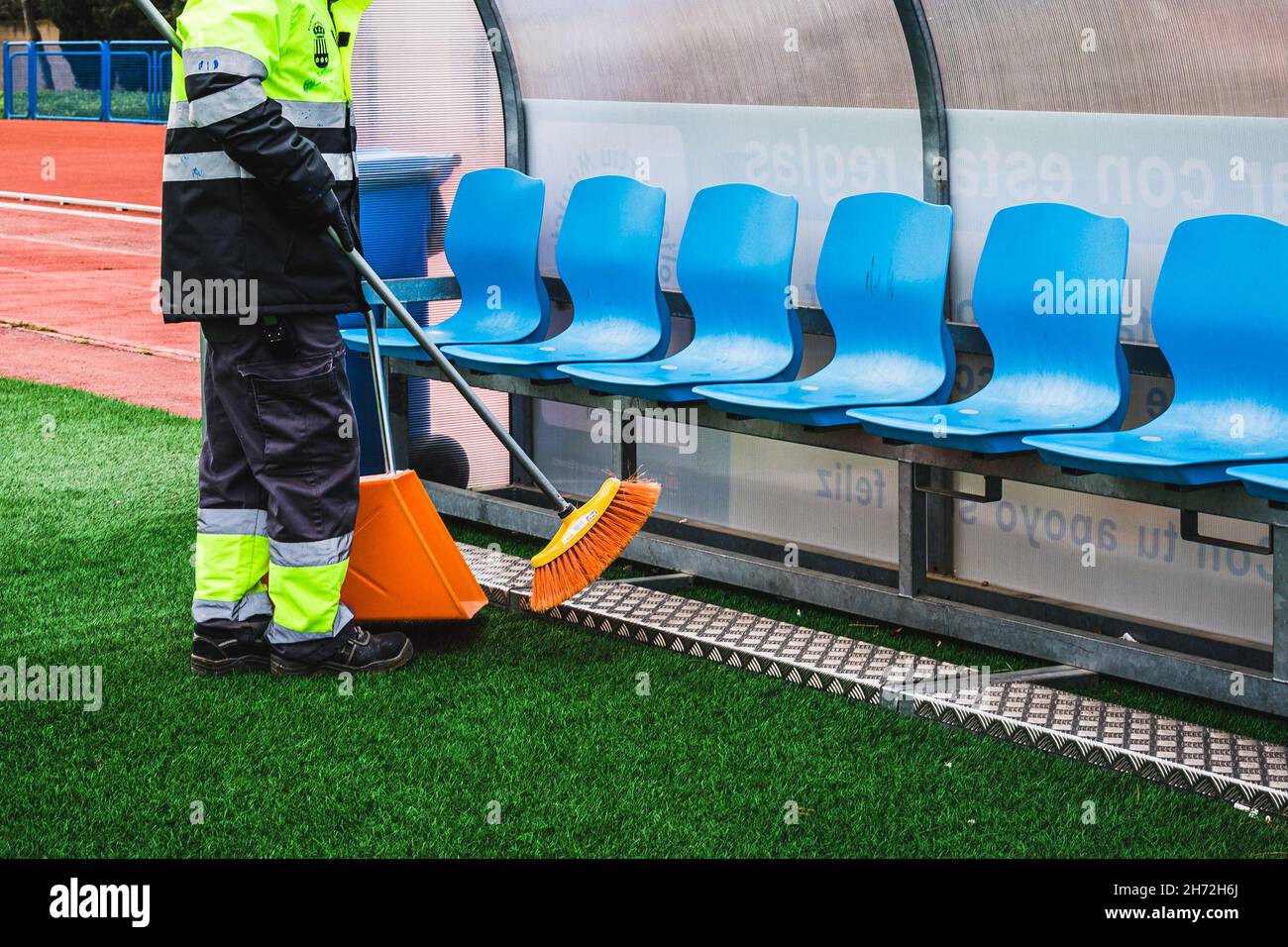 Worker in a special uniform cleaning the football pitch Stock Photo - Alamy