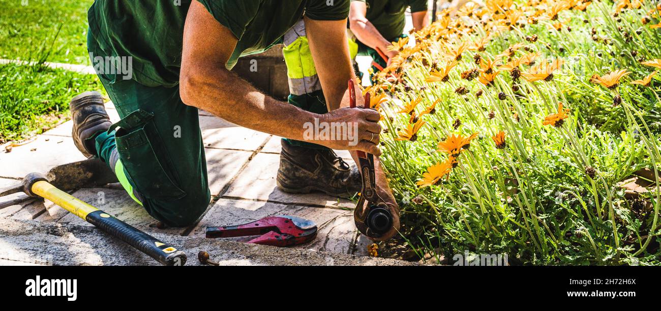 Worker in a special uniform fixing the tubes in the yard Stock Photo ...