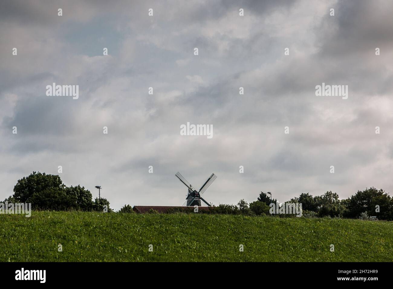 Big windmill in the green countryside and a cloudy sky Stock Photo - Alamy