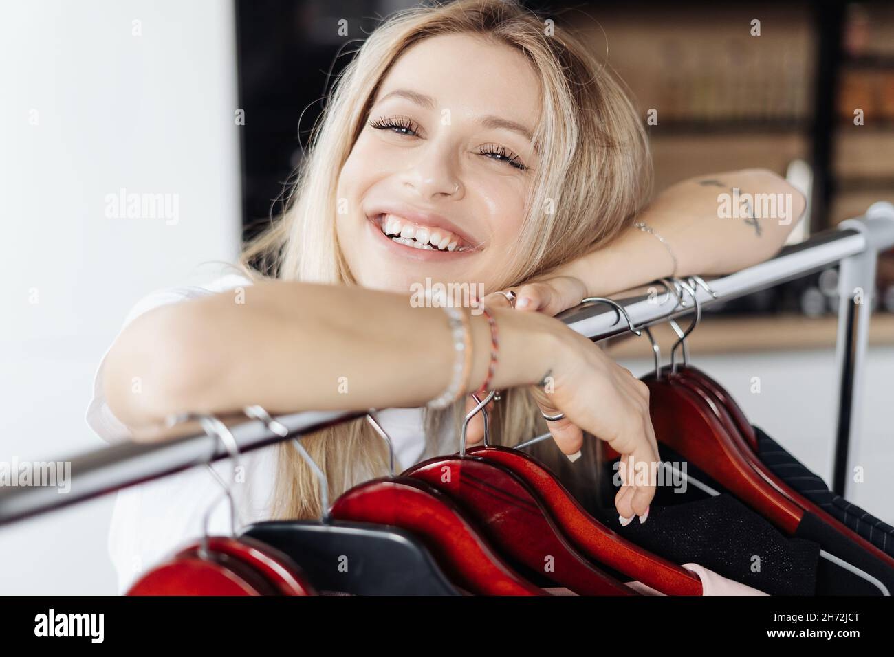 Excited Shopaholic Lady Smiling Posing Near Clothing Rack With Hangers ...