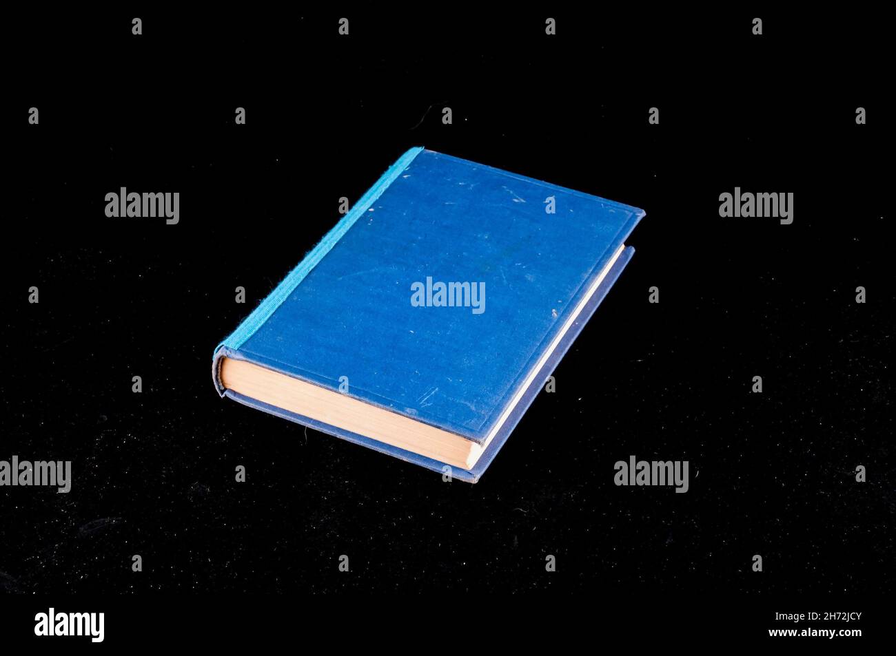 Image of an old blue-covered book with a black background; top view ...