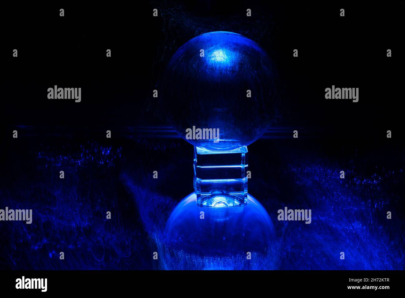 Closeup shot of a glowing crystal ball with blue lights on dark ...