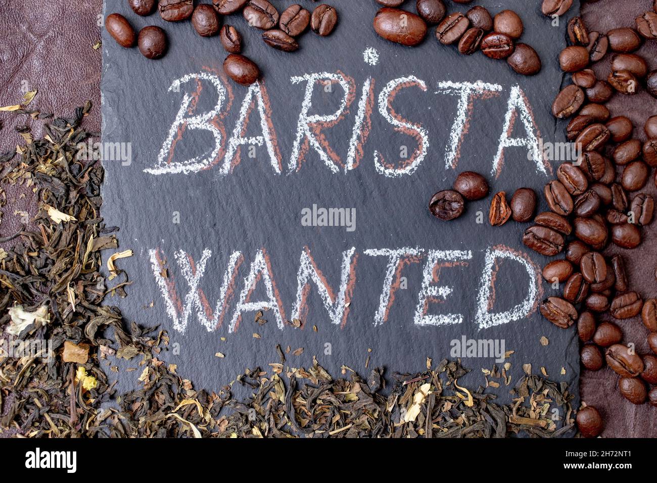 Barista wanted written with chalk on a black stone tile, surrounded by ...
