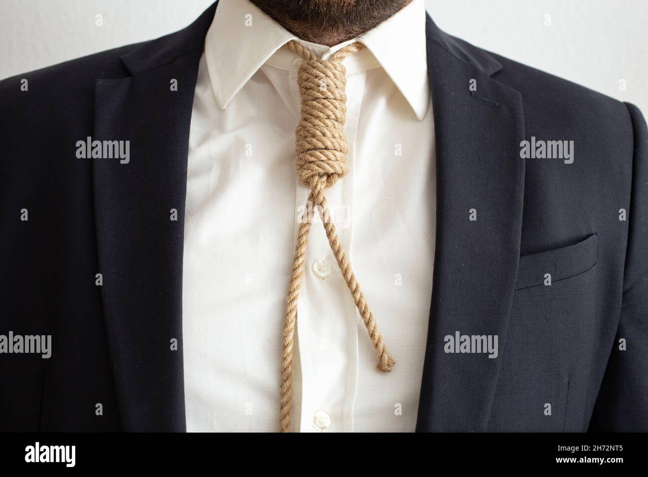 man in dark suit wearing a rope with hangman noose, as a tie Stock ...
