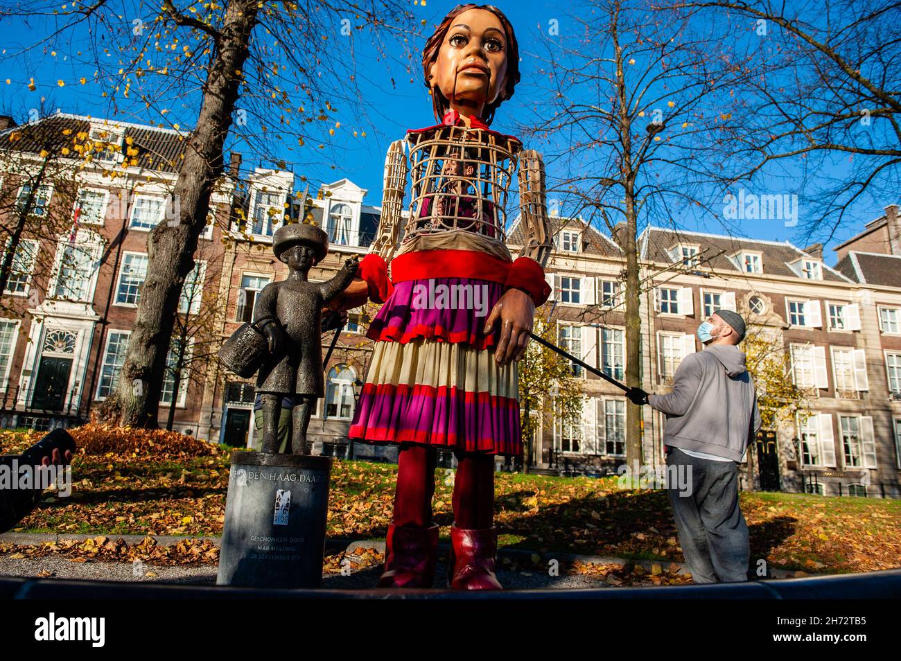 The giant puppet seen posing close to a sculpture of a little kid.On ...