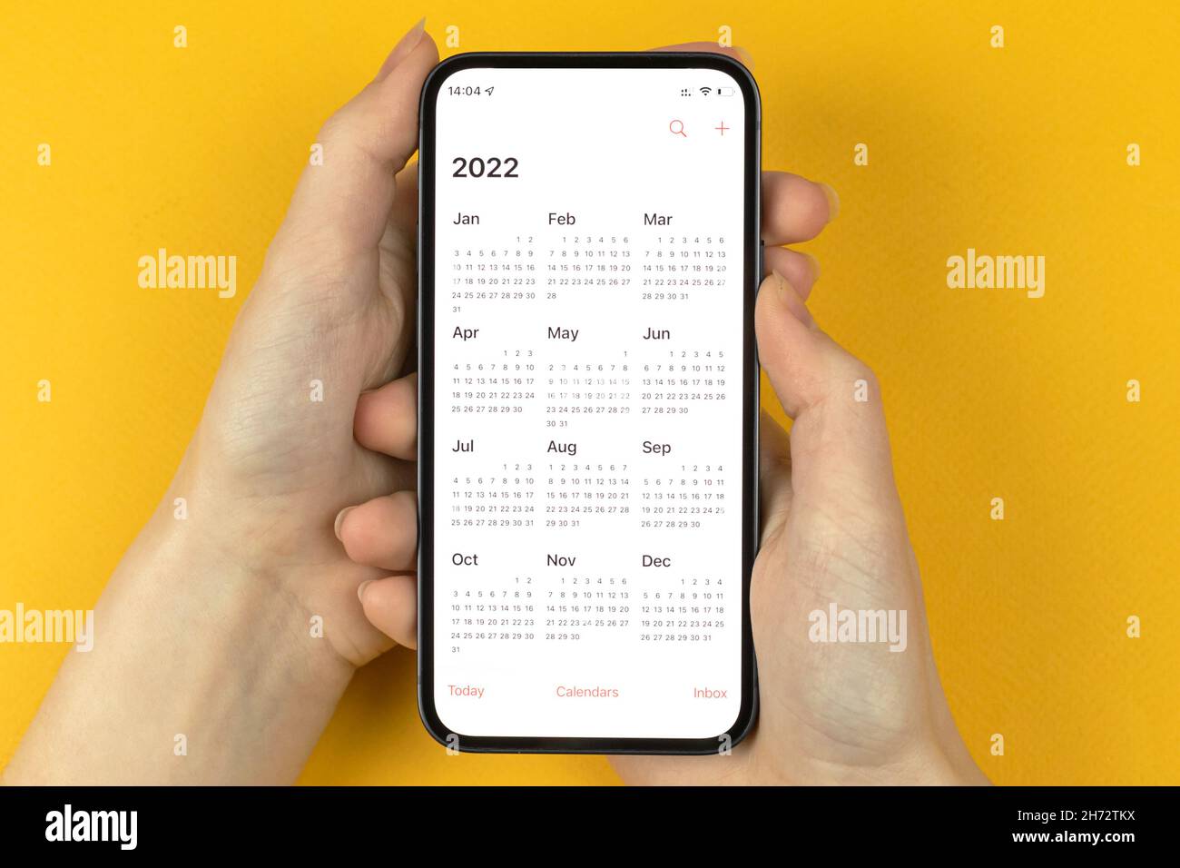 Calendar 2022 app on smartphone screen. Hand with mobile phone. To do ...
