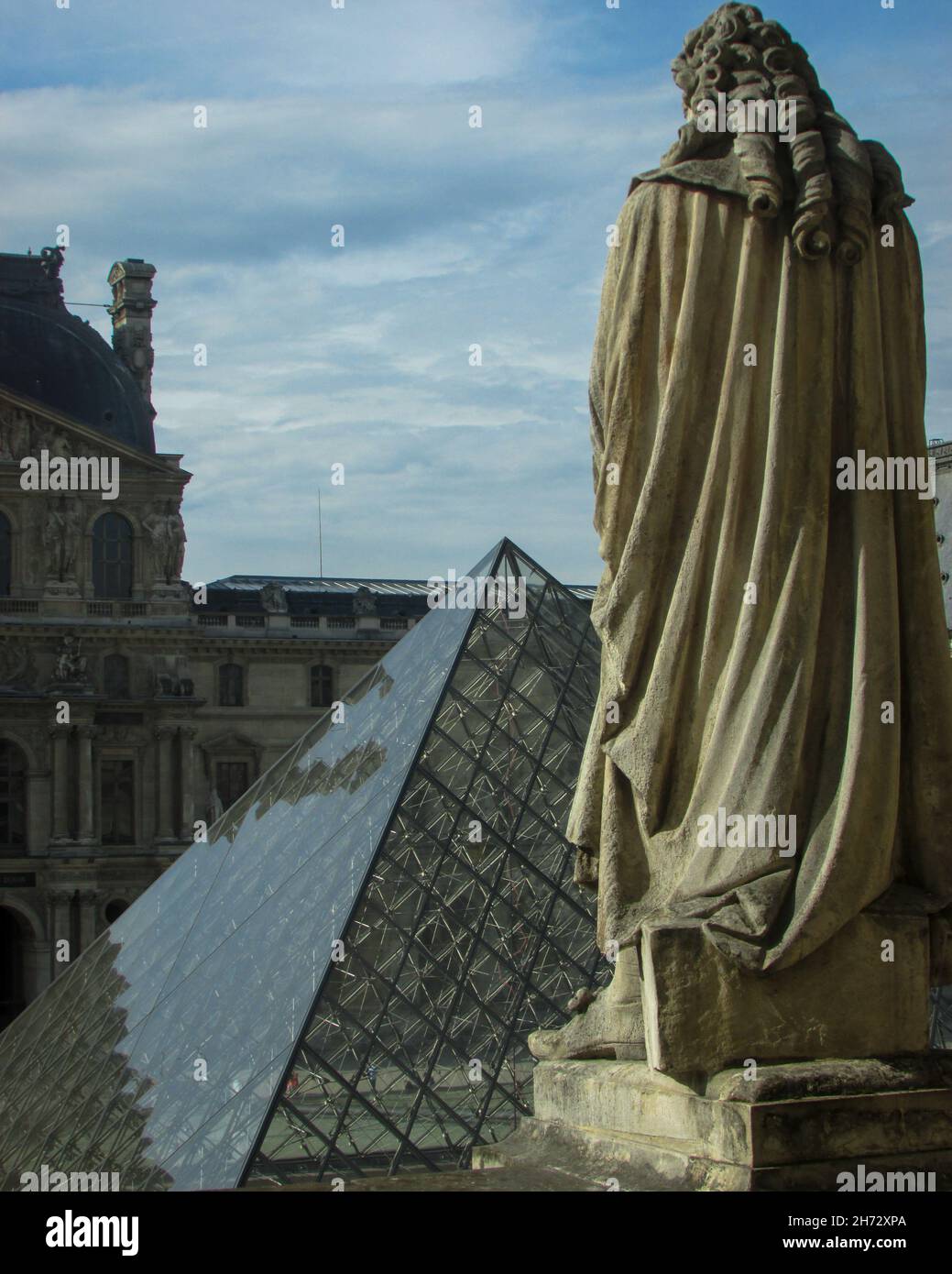 Statue overlooking the Louvre Pyramid Stock Photo - Alamy