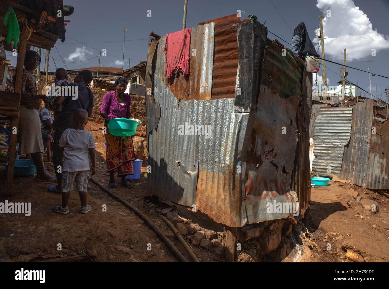 Women sit near an old latrine structure in Kibera Slums.World Toilet ...