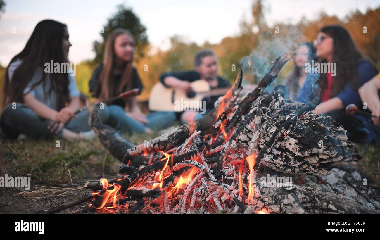 Friends sitting around a fire hi-res stock photography and images - Alamy