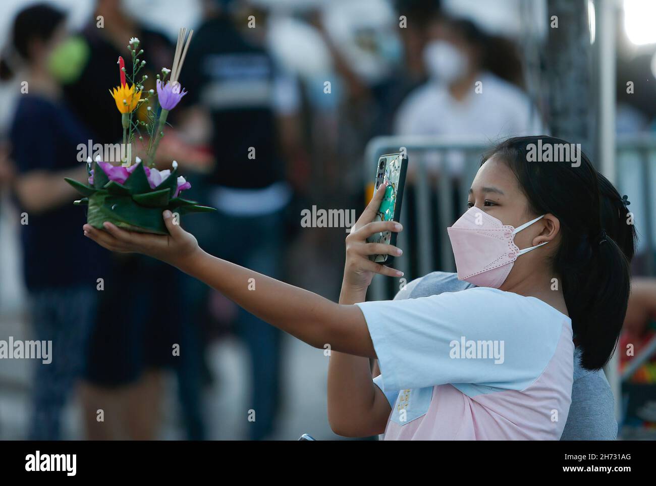 A man carries a krathong into the Chao Phraya river during the Loy ...