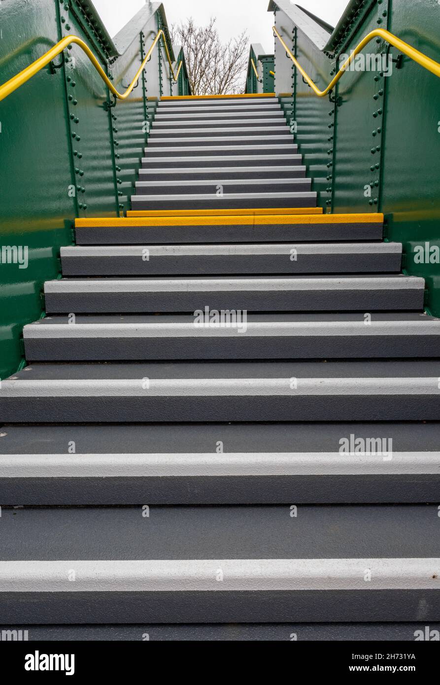 flight of steps at a railway station with yellow edge and handrails to ...