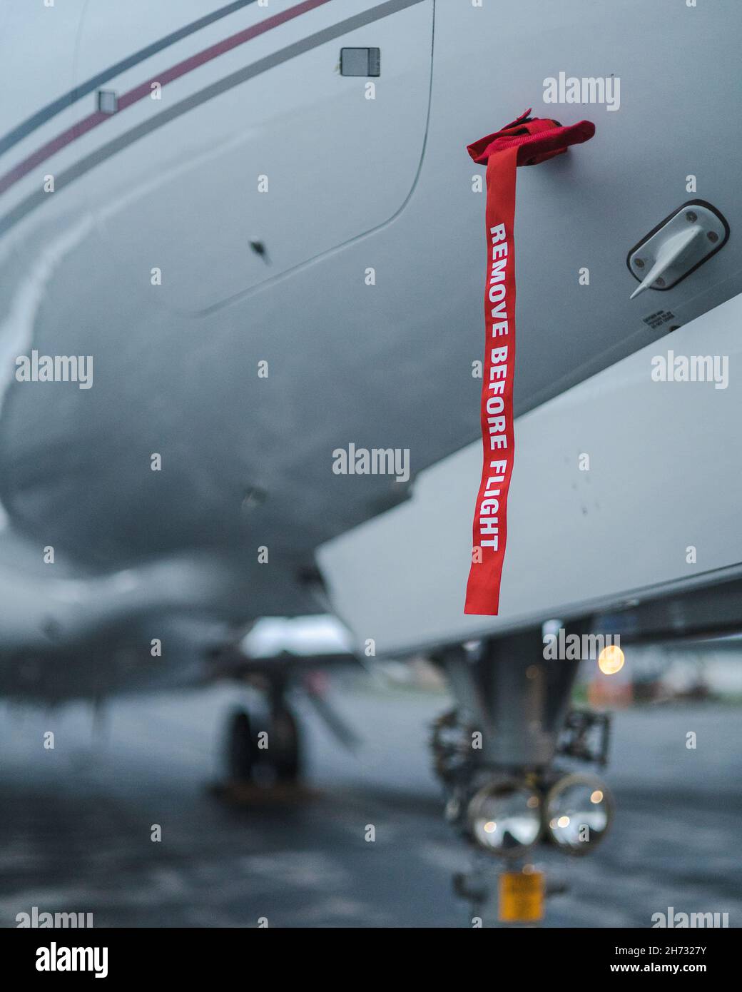 Red tape with the writing "remove before flight" hanging on the plane ...
