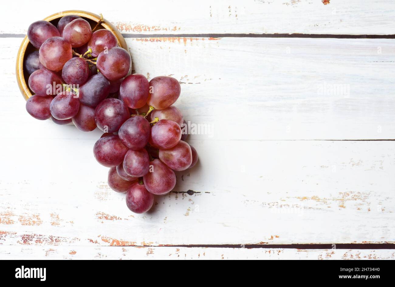 Cluster of red grapes in the grunge wooden background with copy space ...
