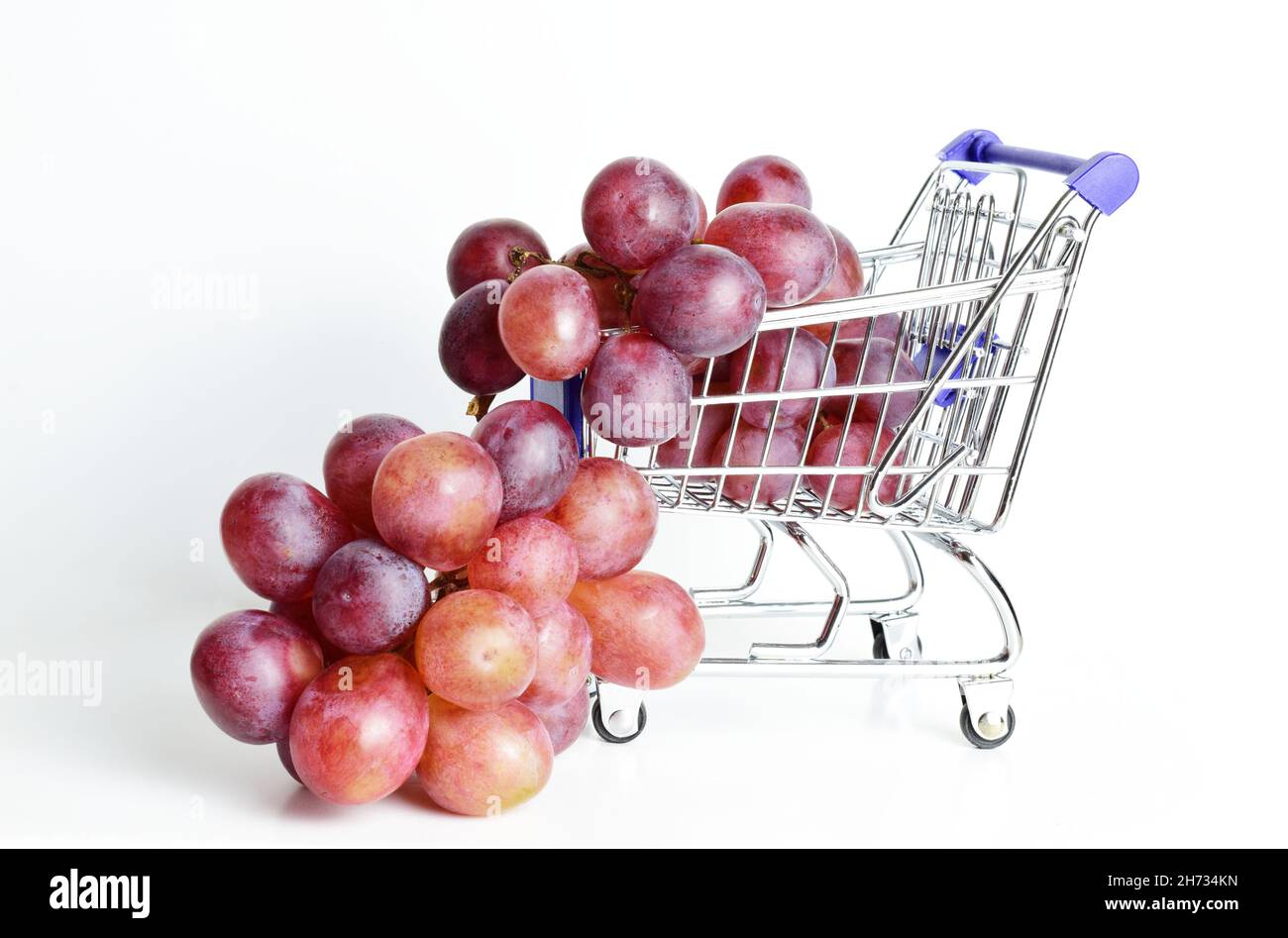 Grape berries in a supermarket shopping cart in the white background ...