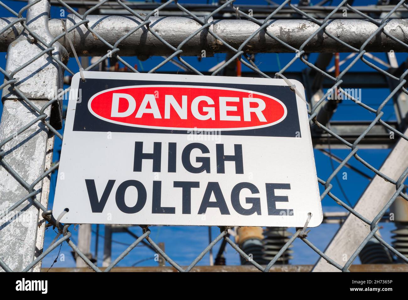 Danger High Voltage sign on chain link fence with power generators in ...