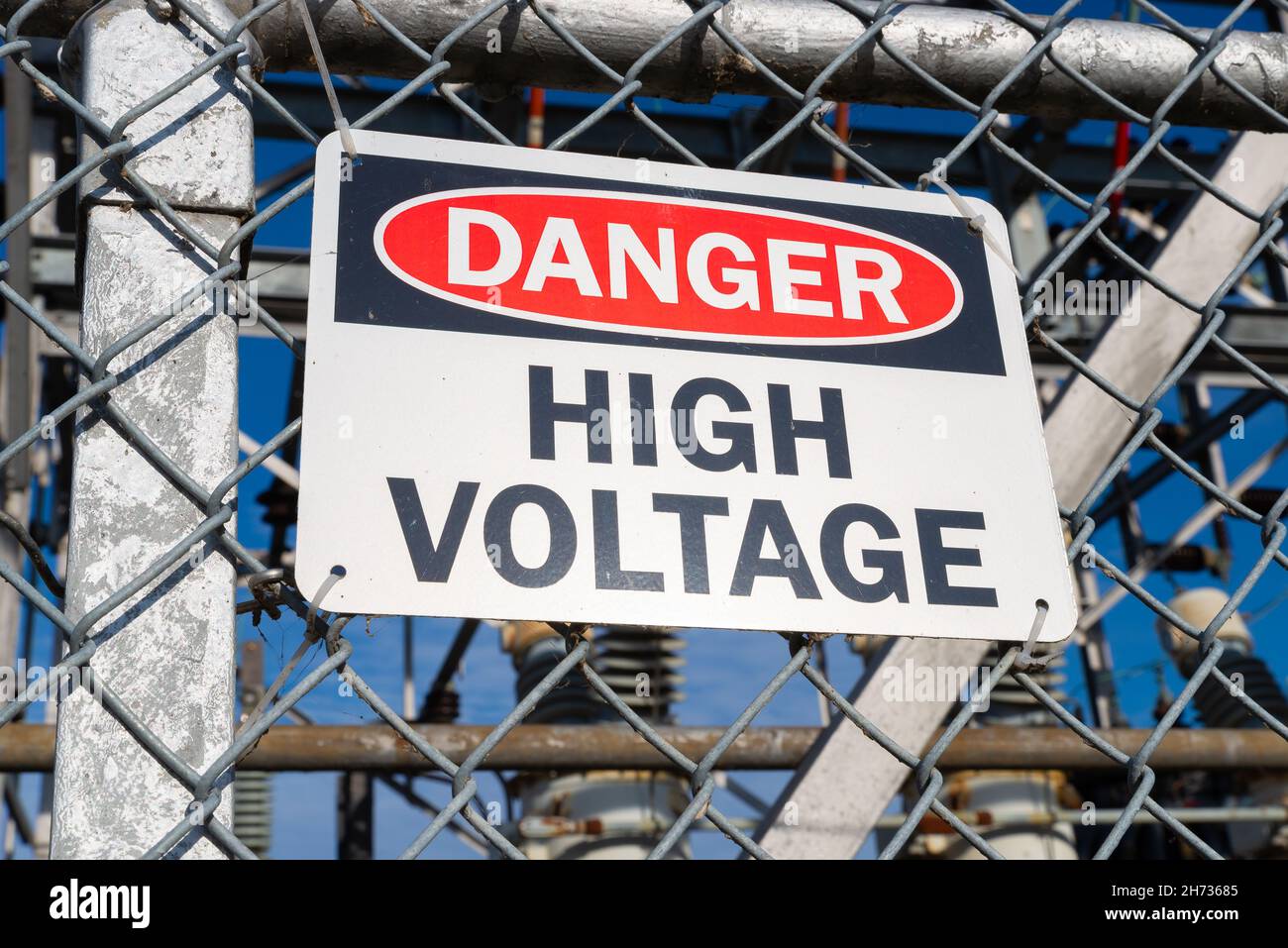 Danger High Voltage sign on chain link fence with power generators in ...