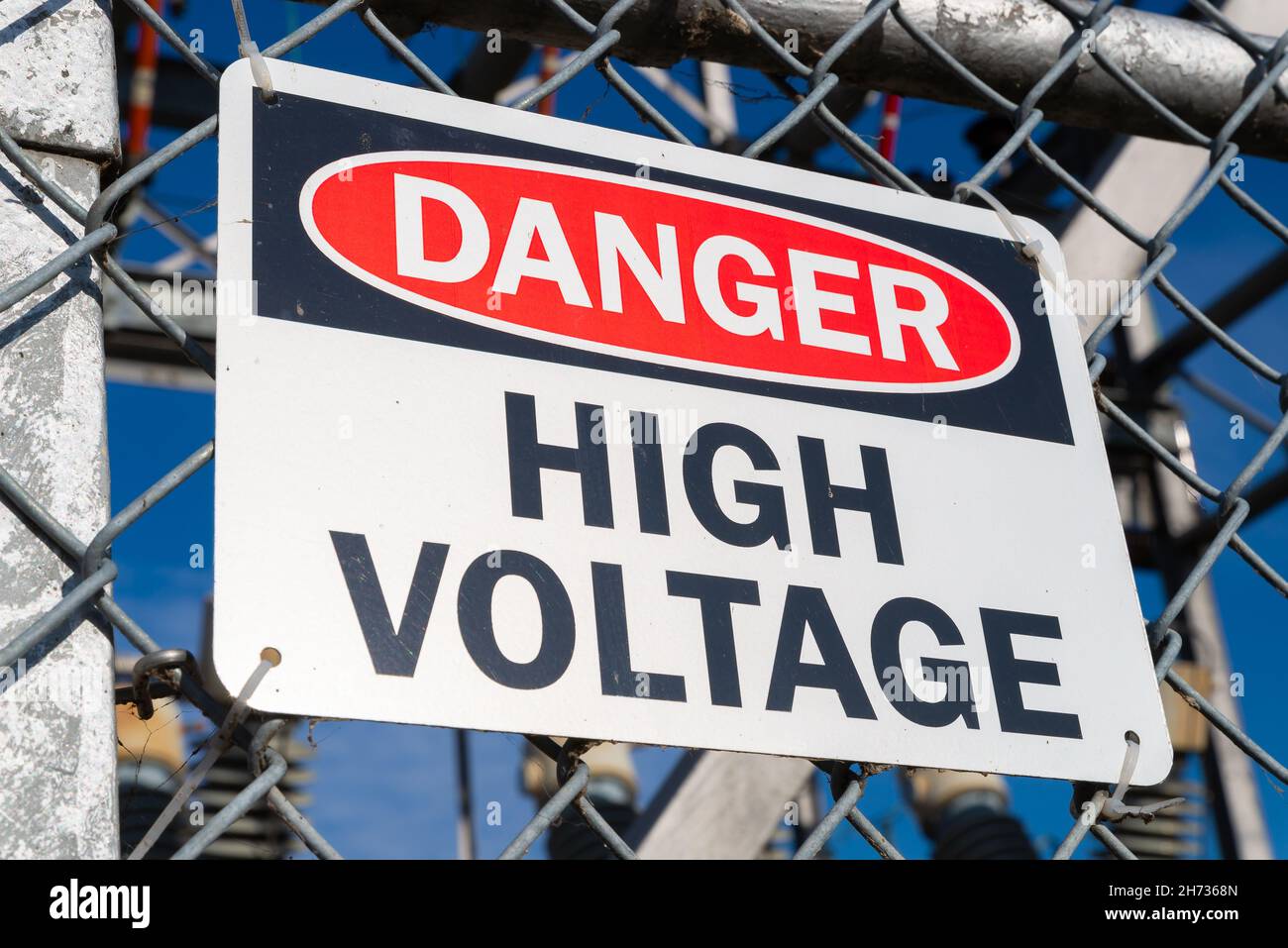 Danger High Voltage sign on chain link fence with power generators in ...