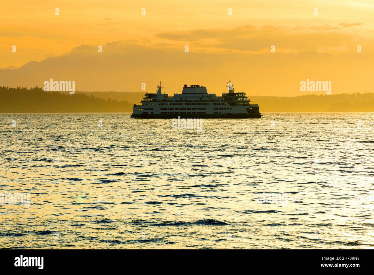 Large ferry boat sailing across water at sunset Stock Photo - Alamy