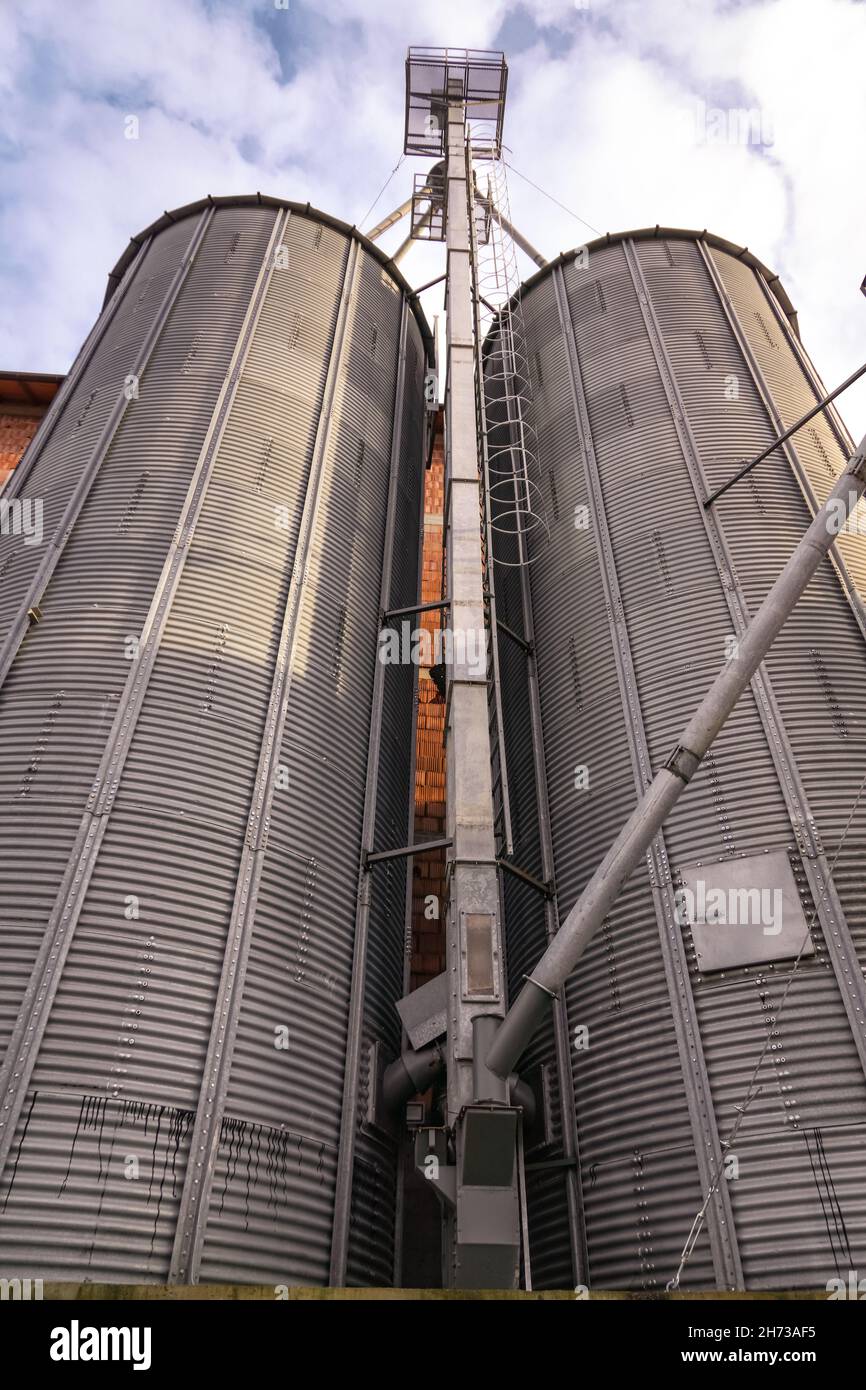 Low angle shot of two stainless cylindrical silo containers used in ...