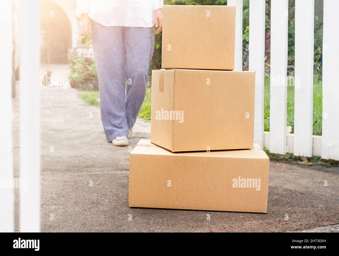 A woman go to the parcel box delivered to the gate of the house Stock ...