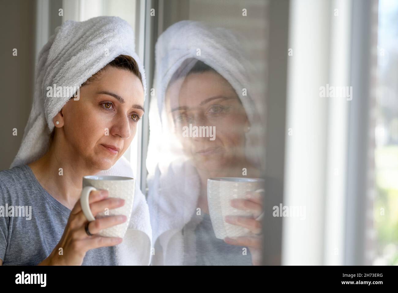 Moody photo of a middle aged woman with towel turban on her head during ...