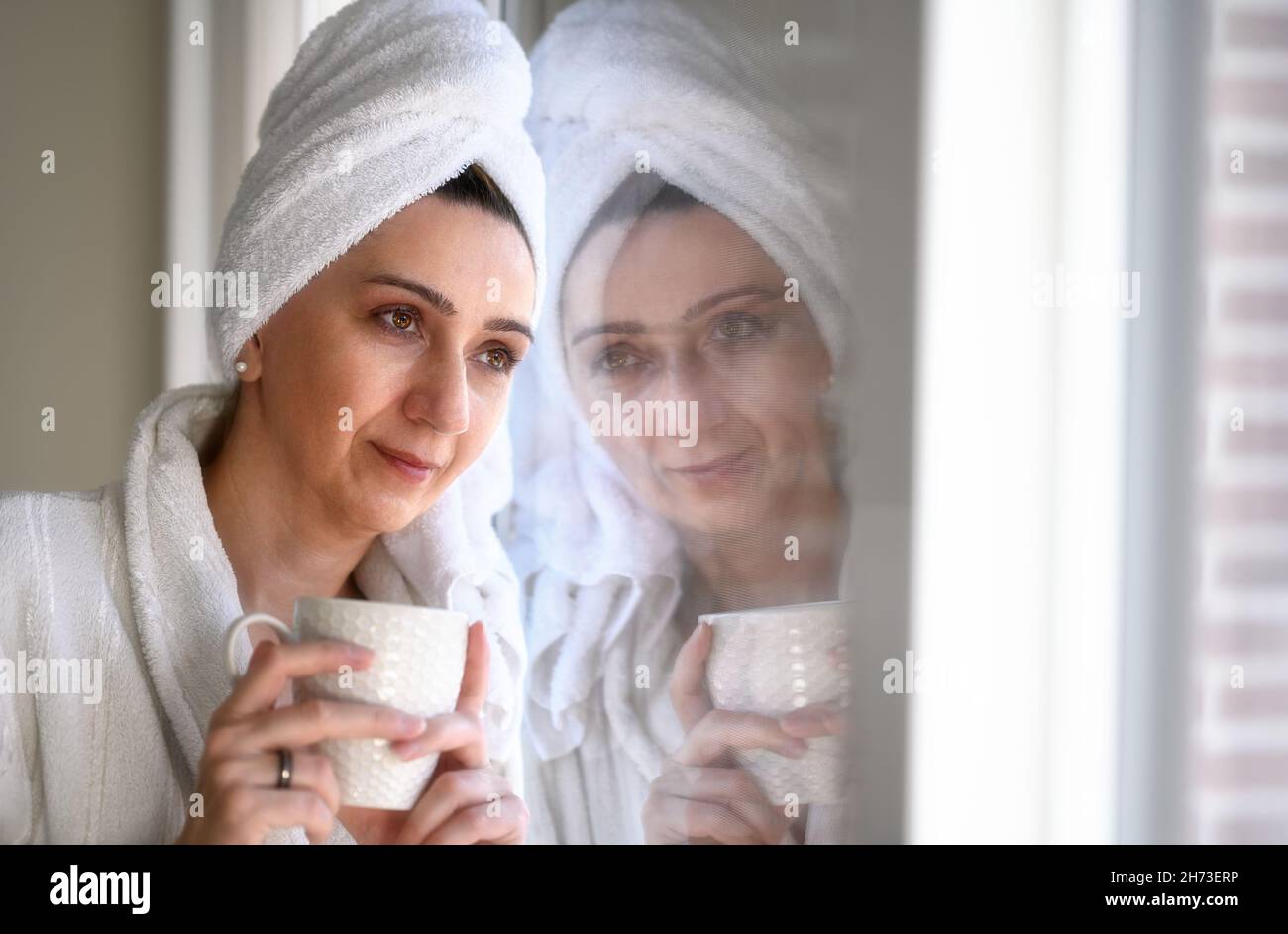 Moody photo of a middle aged woman with towel turban on her head during ...