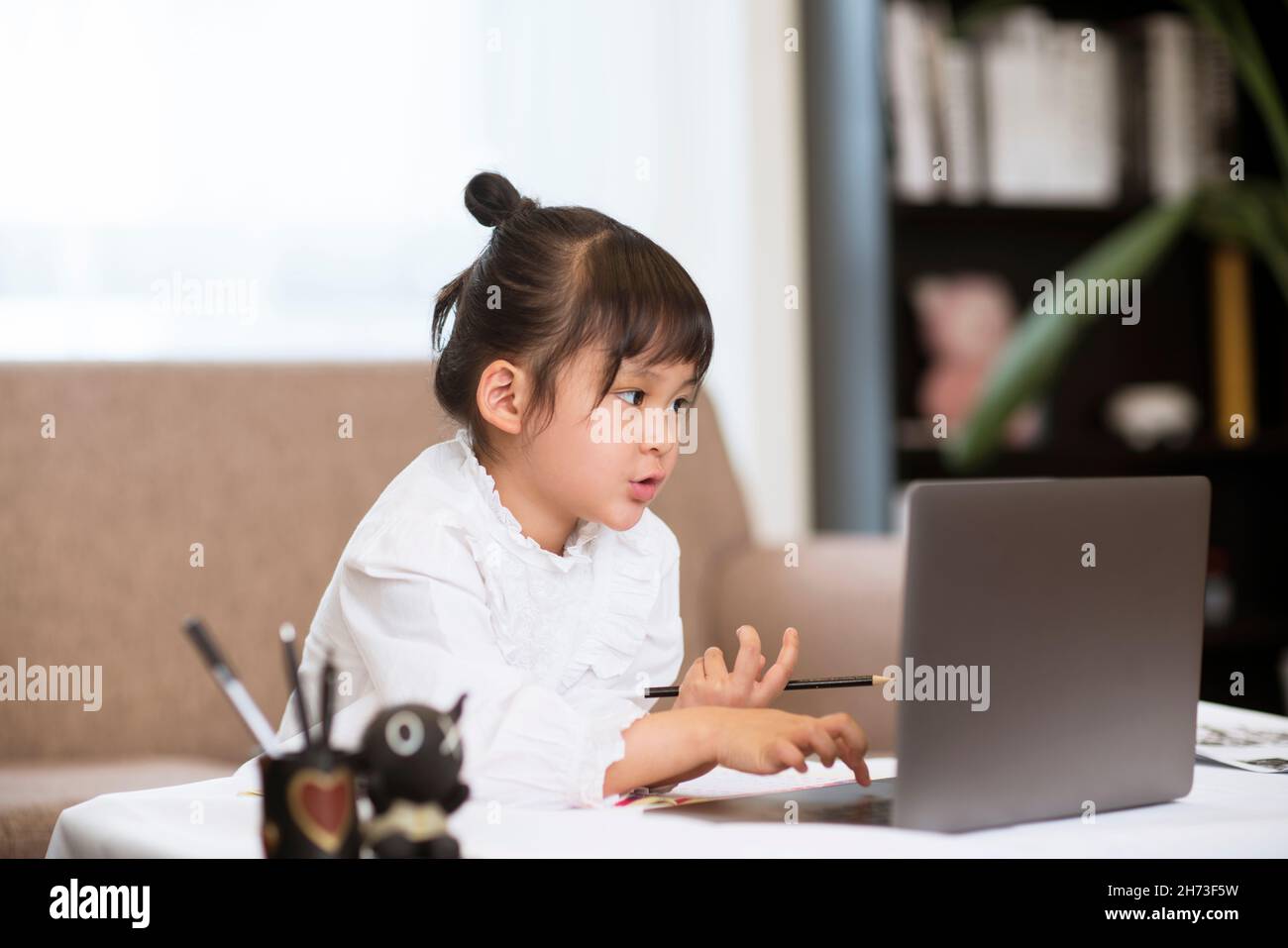 Little cute girl learning online Stock Photo - Alamy