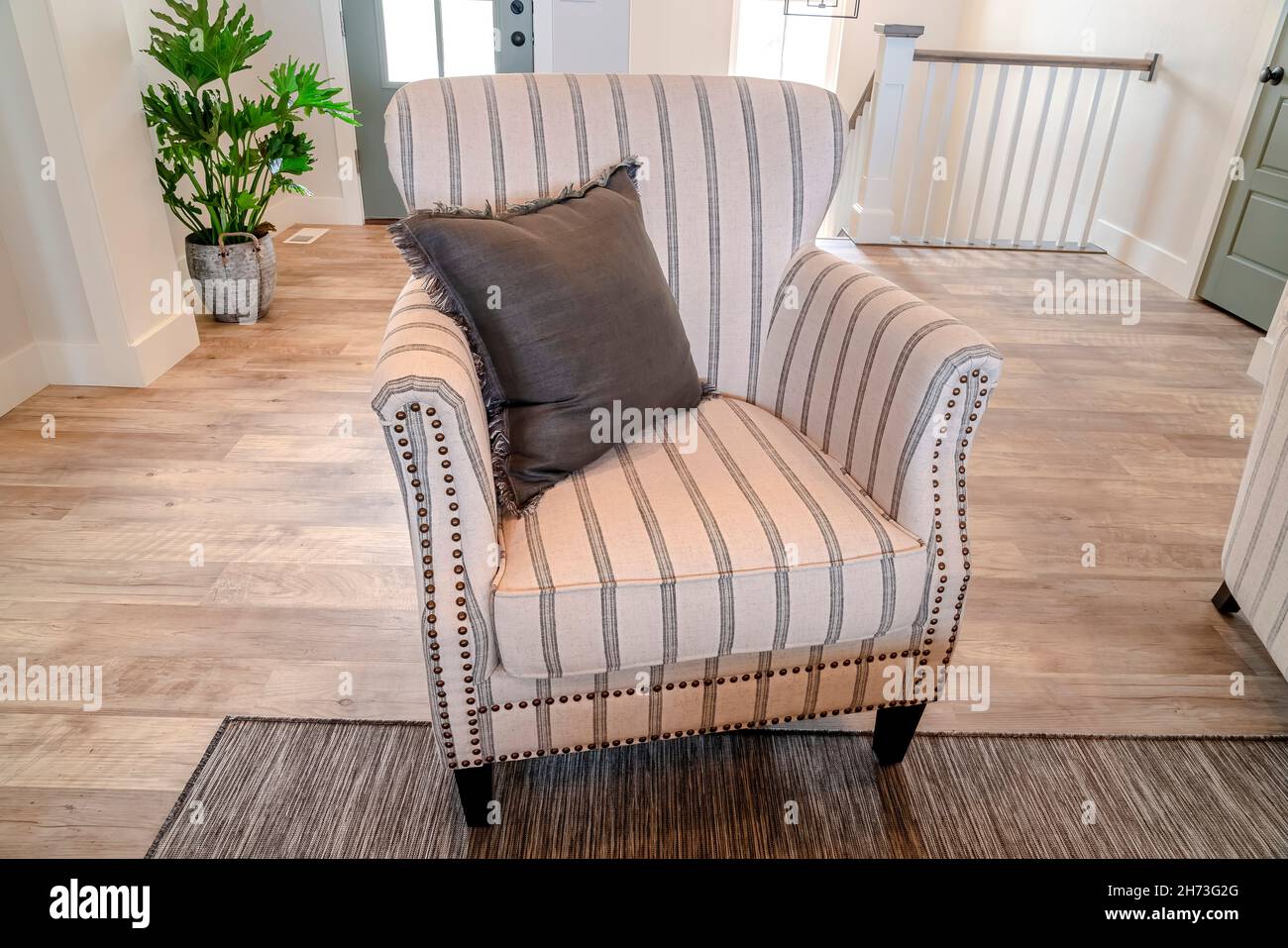 Living room interior with armchair against front door and indoor stairs ...