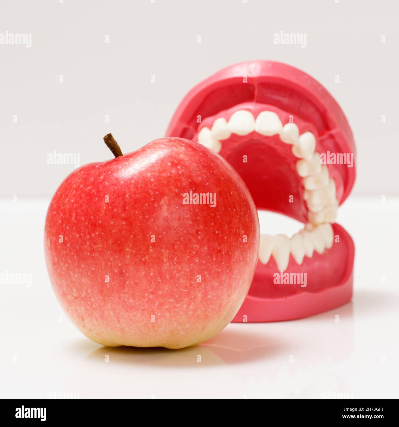 Apple with a layout of the human jaw on the background Stock Photo - Alamy
