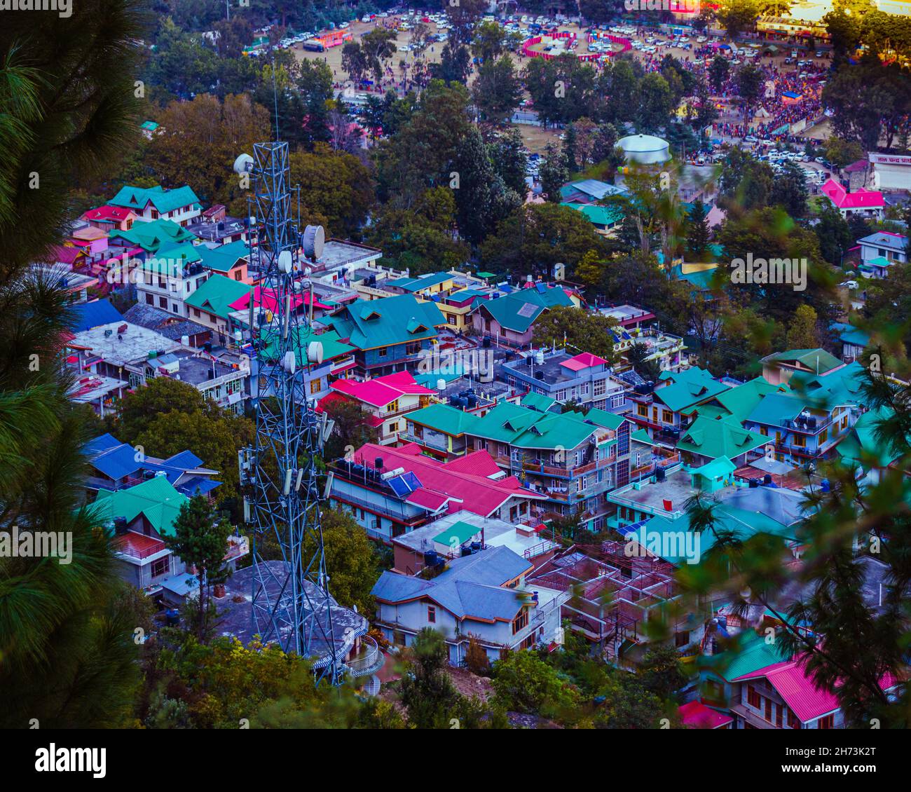 Aerial view of colorful village roofs framed with green foliage Stock ...