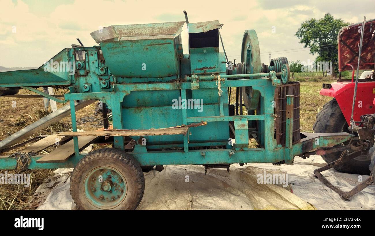 Dirty blue thresher machine in a field Stock Photo - Alamy